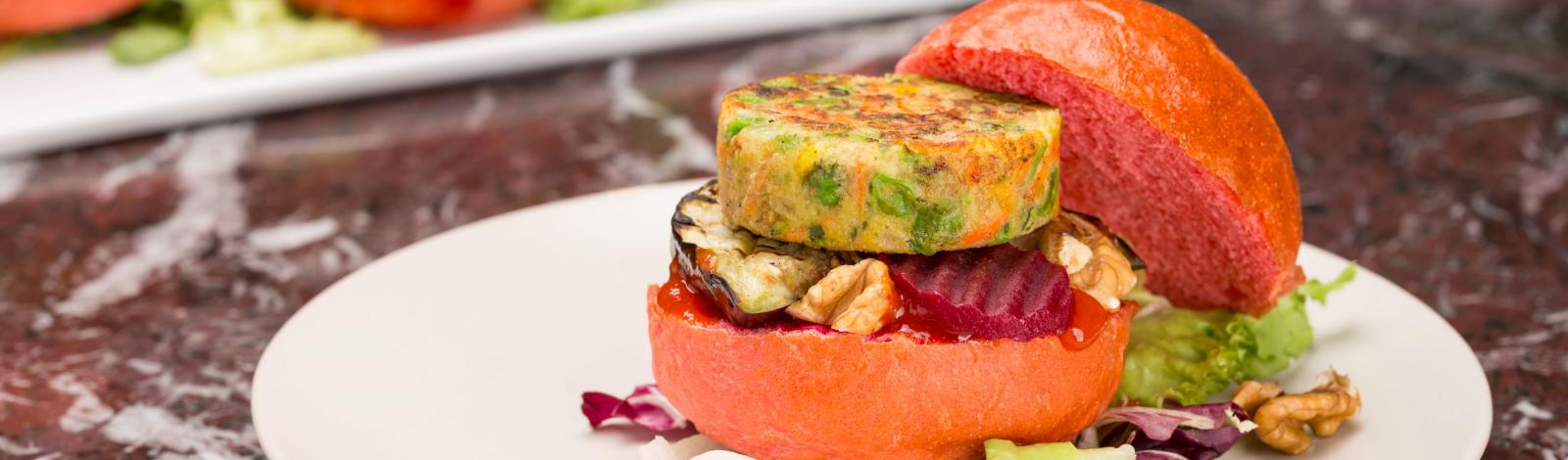 Pan rojo con burger de calabacín, guisantes y zanahorias